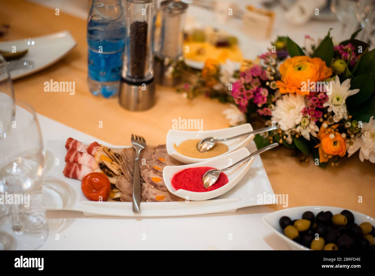 Meat on a white plate on a banquet table. Meat platter with selection ...