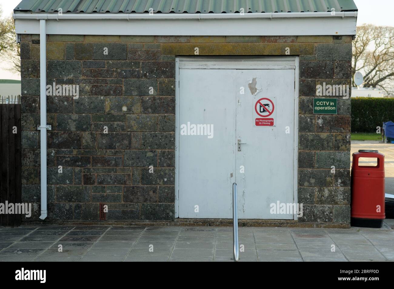 No Photography or Filming sign next to CCTV sign on side of small stone ...