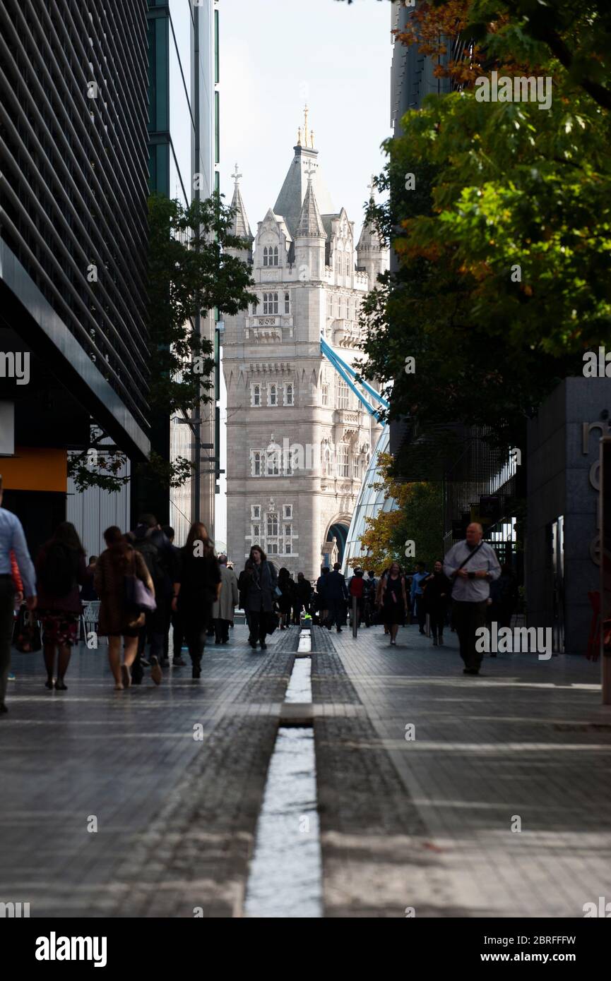 The Tower Bridge seen along a pedestrian walkway between two modern ...