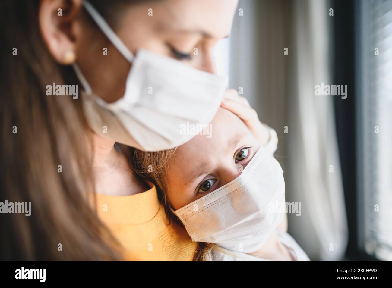 Mother and child with face masks indoors at home, Corona virus and ...