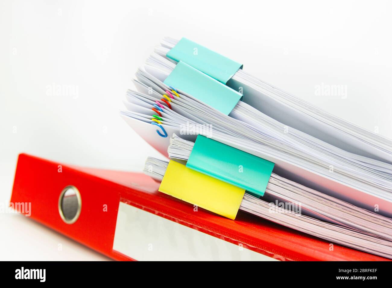 red folder with paper file retention of contracts on white background ...