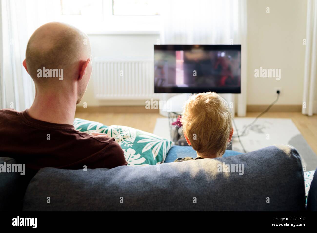 Little boy with his father watching movie on TV screen at home Stock ...