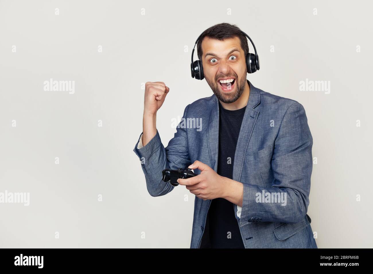 European male gamer playing a video game with headphones on an isolated ...