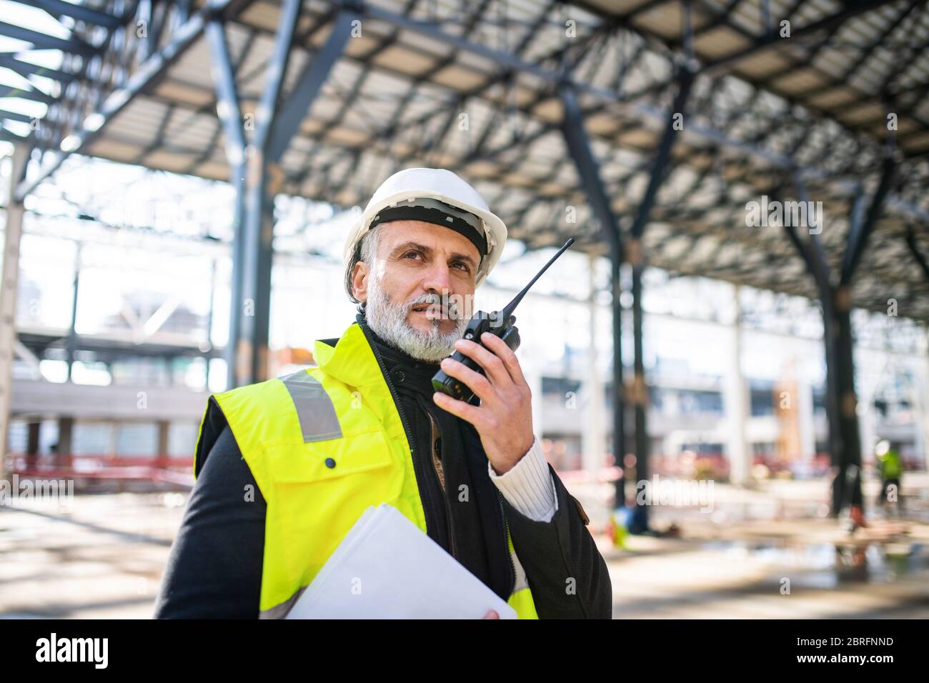 Man engineer using walkie talkie on construction site Stock Photo - Alamy