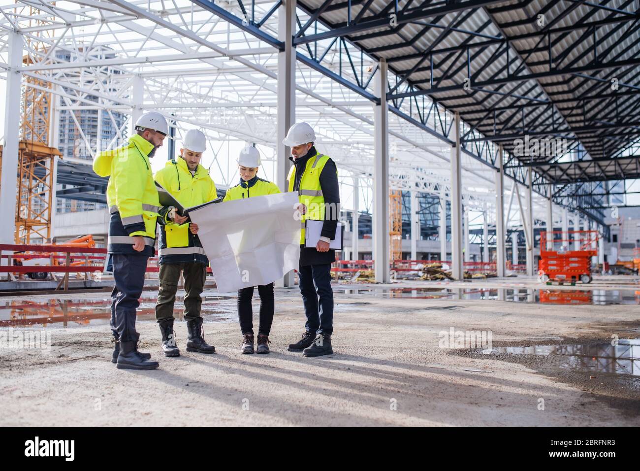 Group of engineers with blueprints standing on construction site Stock ...