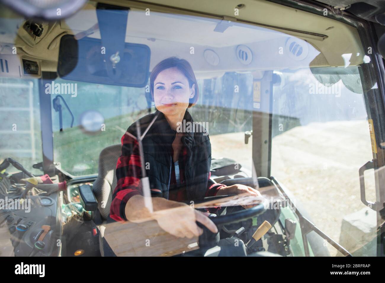 Woman worker riding tractor on diary farm, agriculture industry Stock ...
