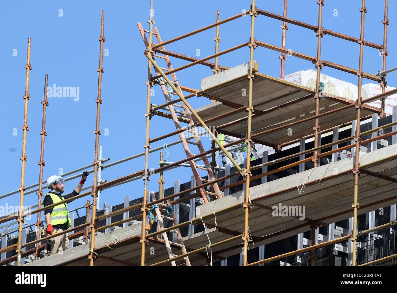 A construction worker wears a face shield on a construction site in ...