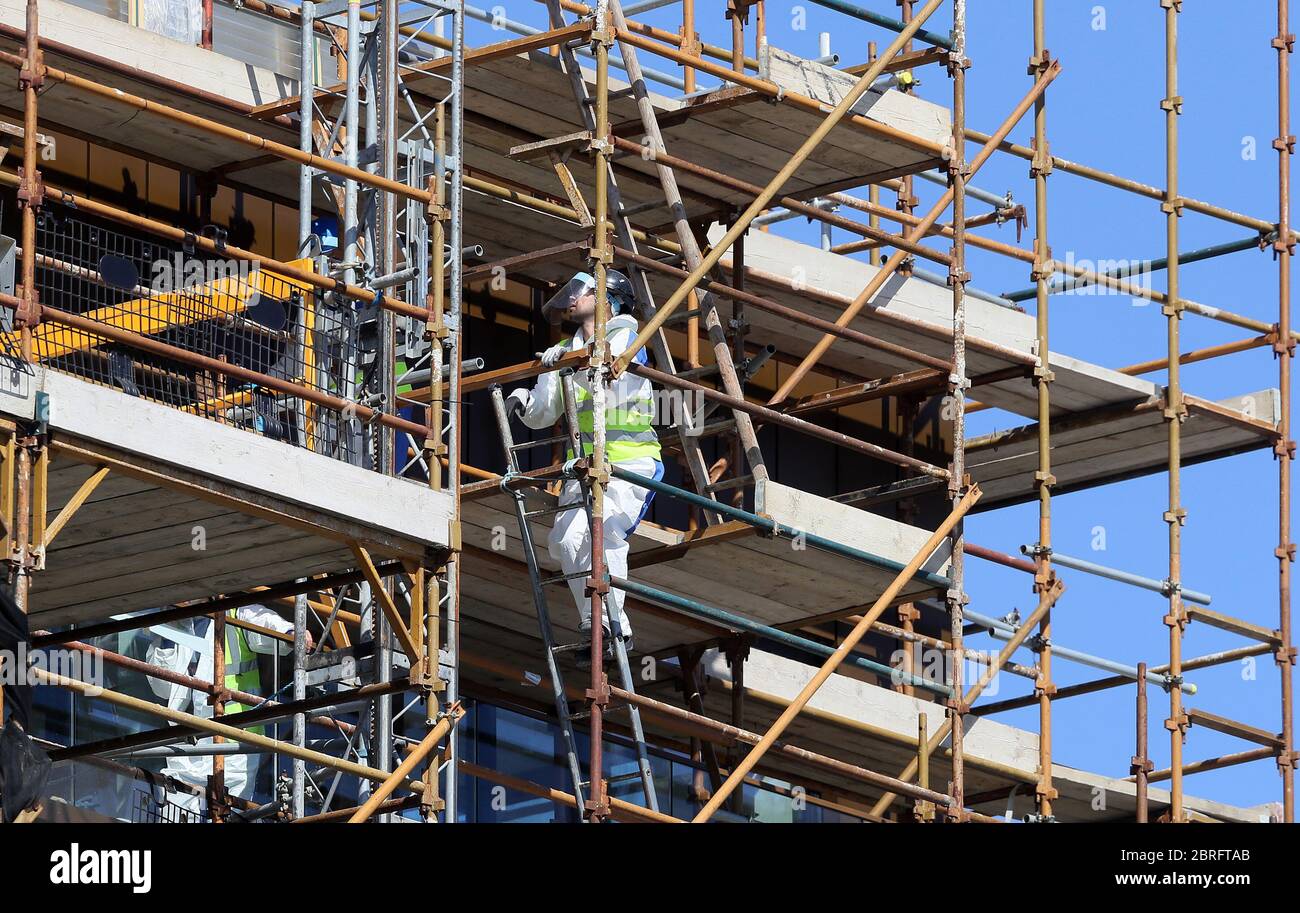 A construction worker wears a face shield on a construction site in ...