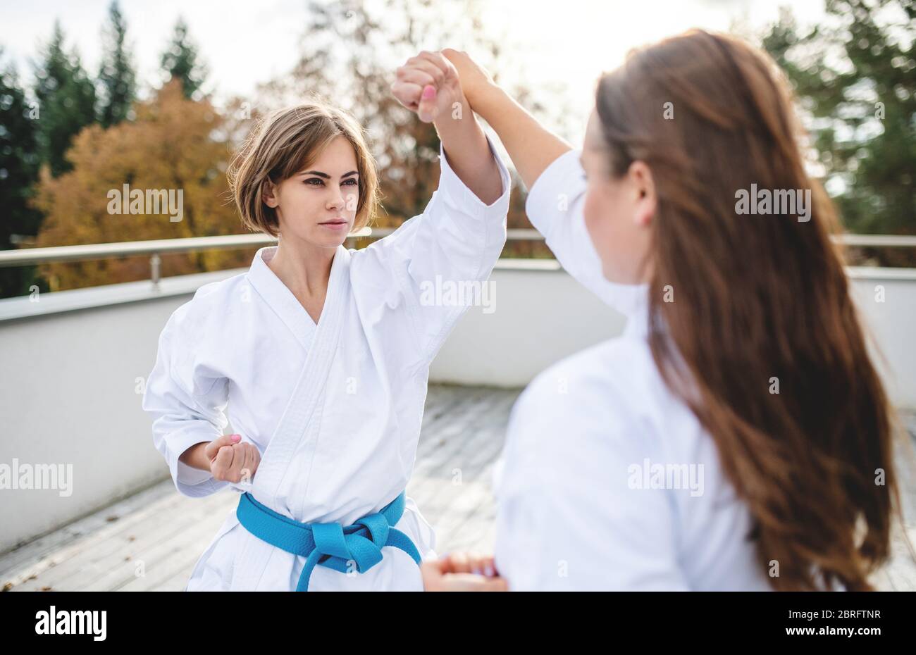 Young women practising karate outdoors on terrace Stock Photo - Alamy