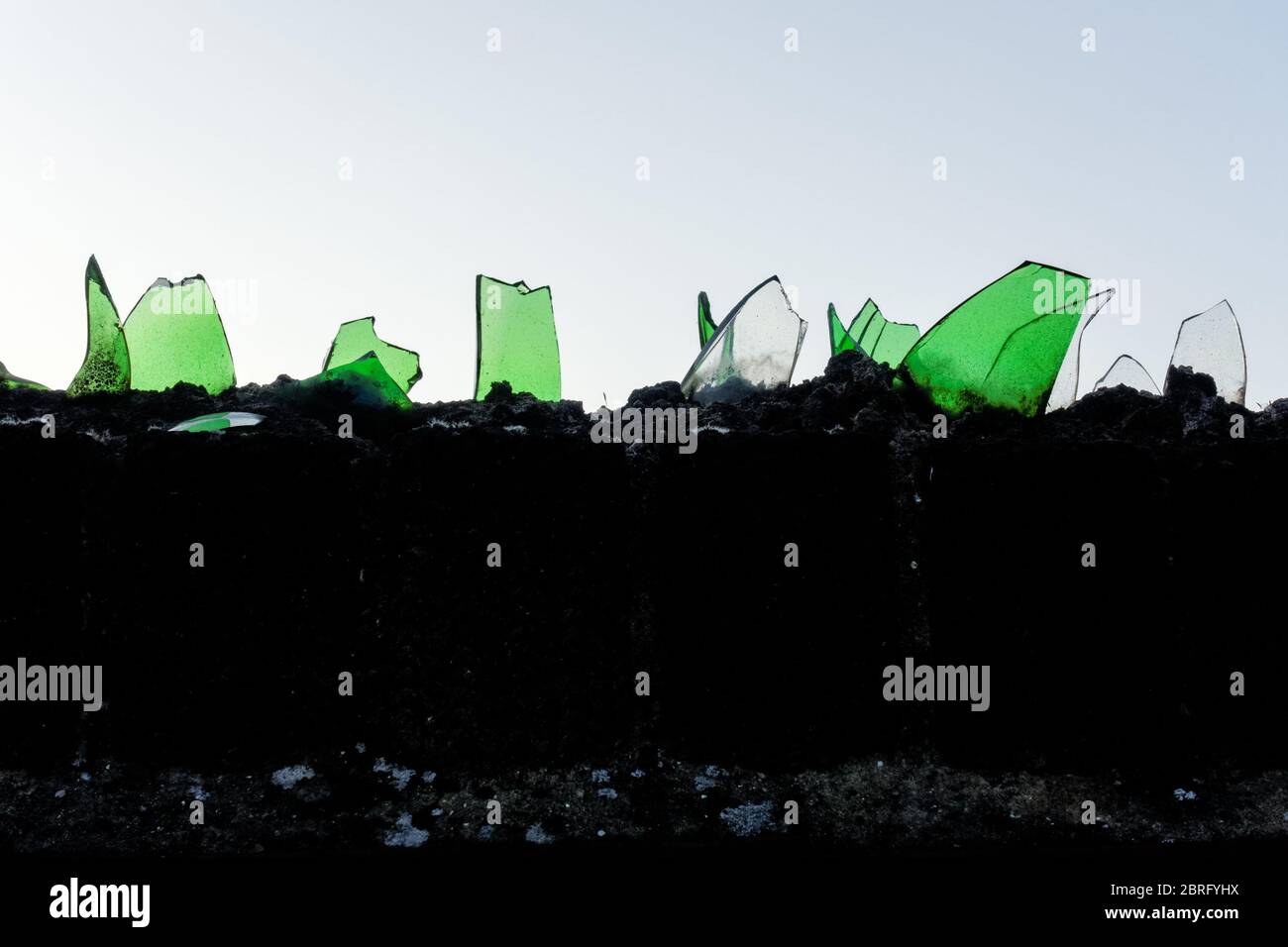 Glass shards on top of a wall Stock Photo - Alamy