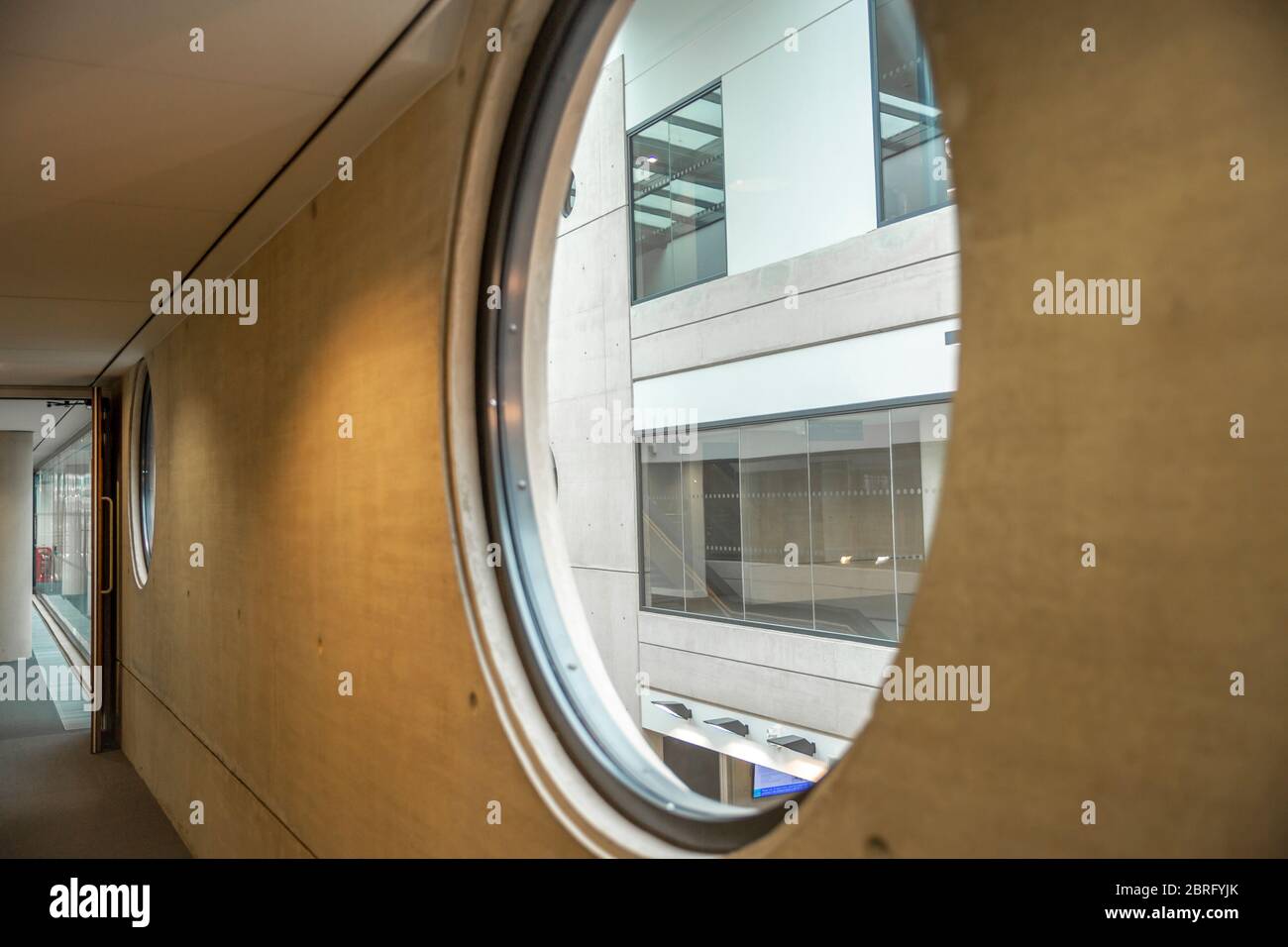 Large round windows on a grey concrete wall in a straight row. Another ...