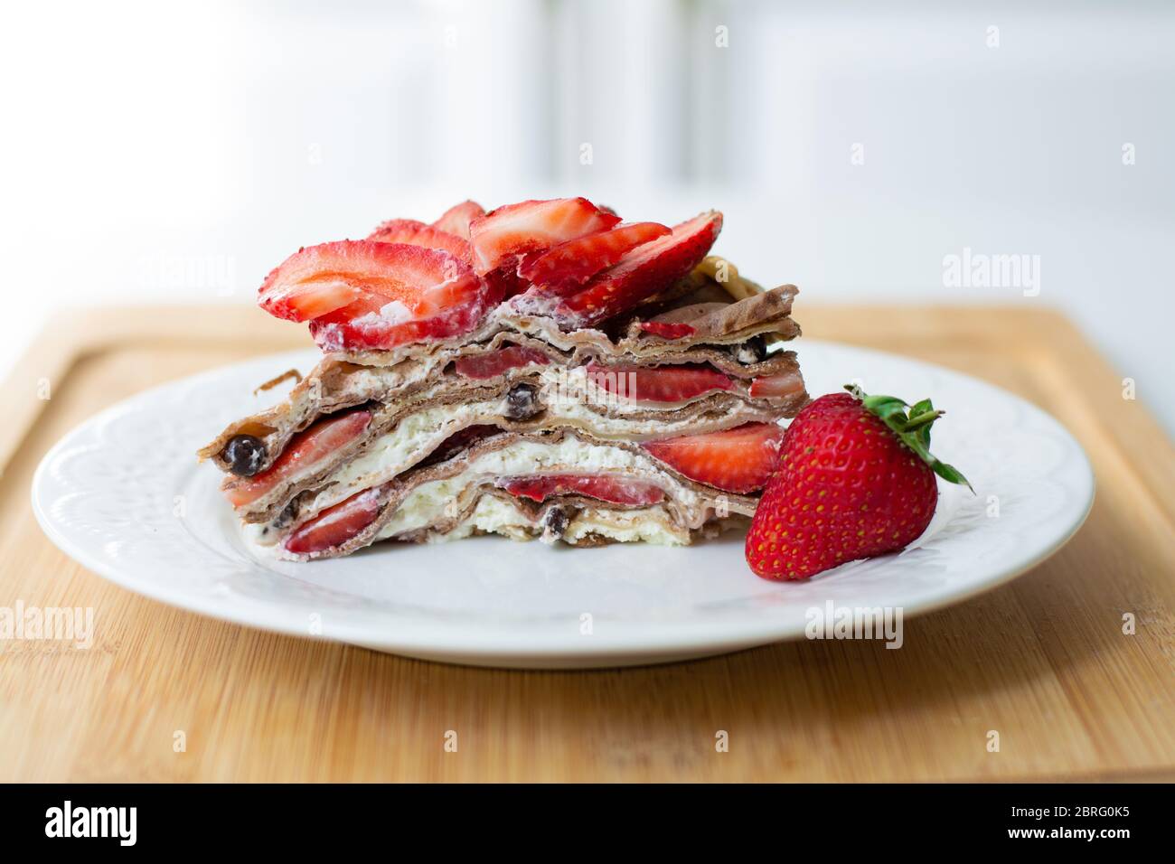 Light summer dessert: a slice of crepe layer cake with whipped cream ...