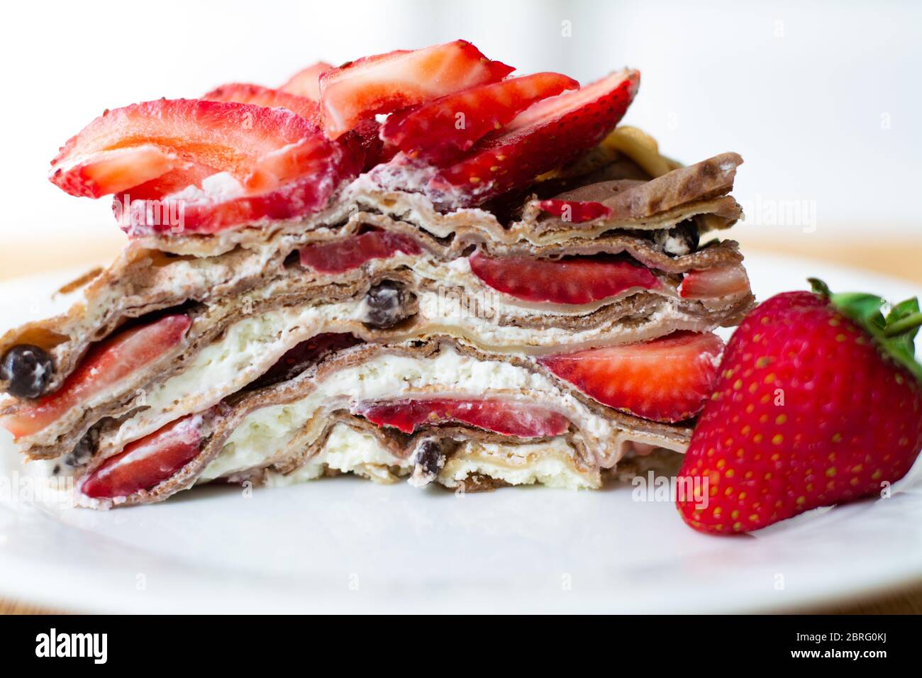 Light summer dessert: a slice of crepe layer cake with whipped cream ...
