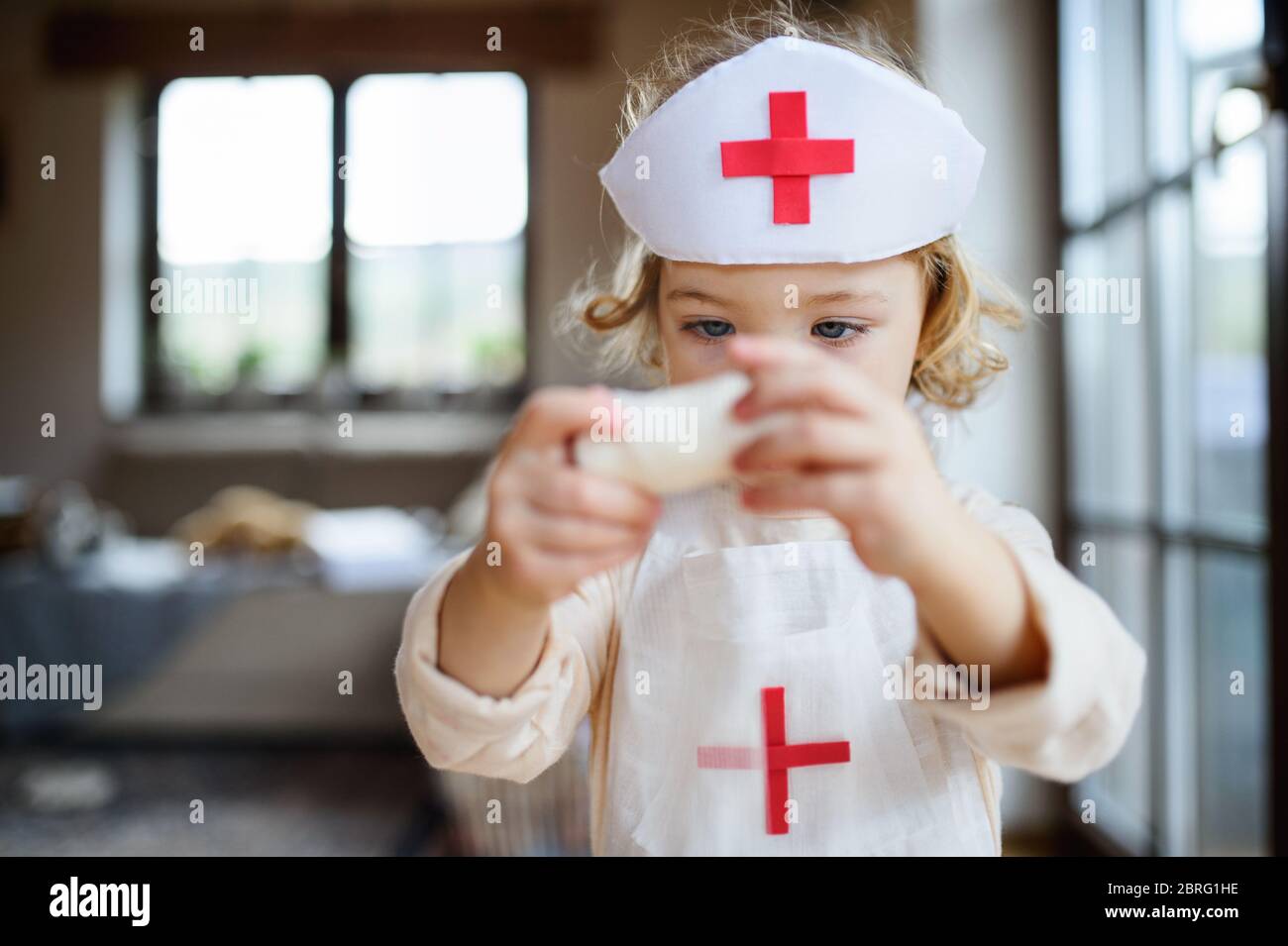 Smal toddler girl with doctor uniform indoors at home, playing Stock ...