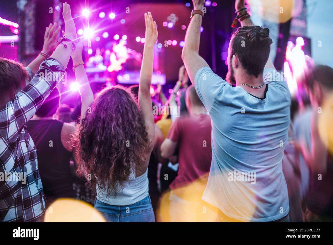 Rear view of group of young friends dancing at summer festival Stock ...