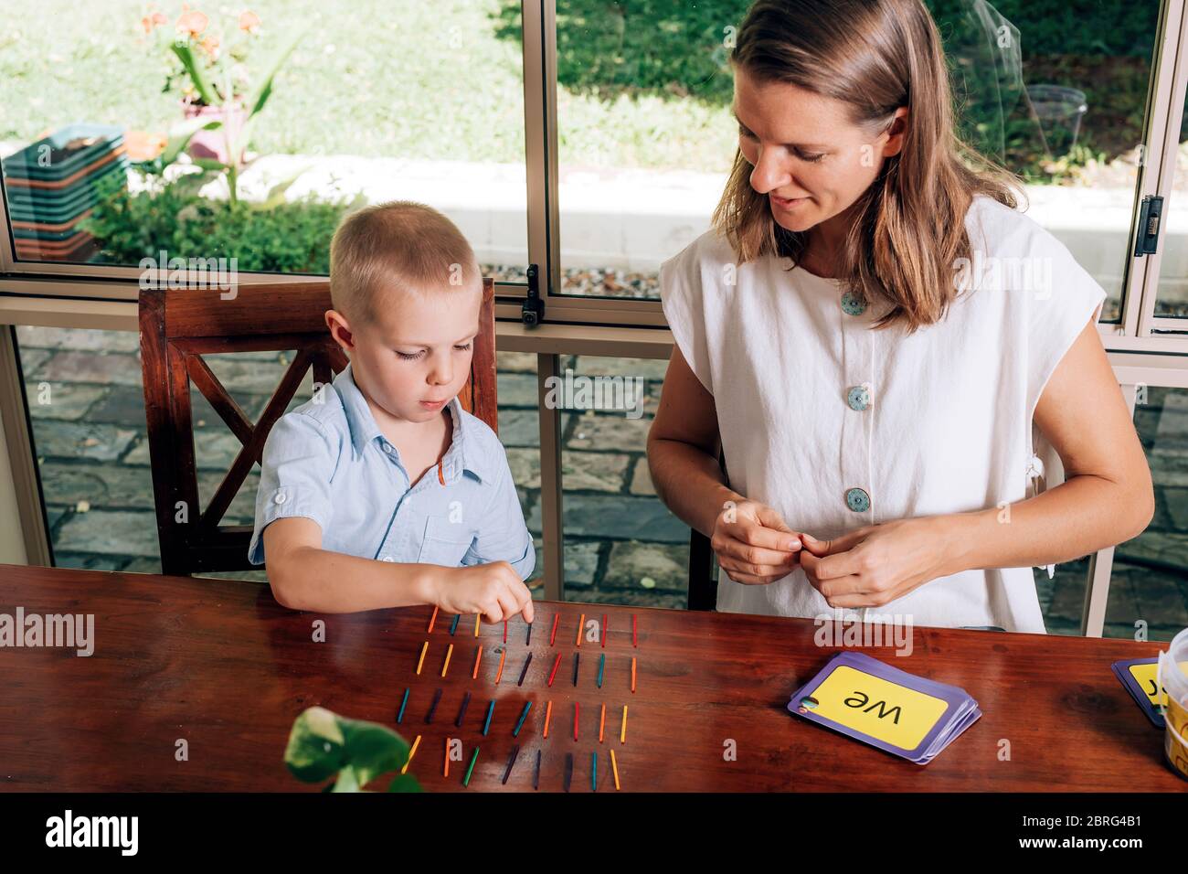 Mother and her little son doing the counting and reading together and ...