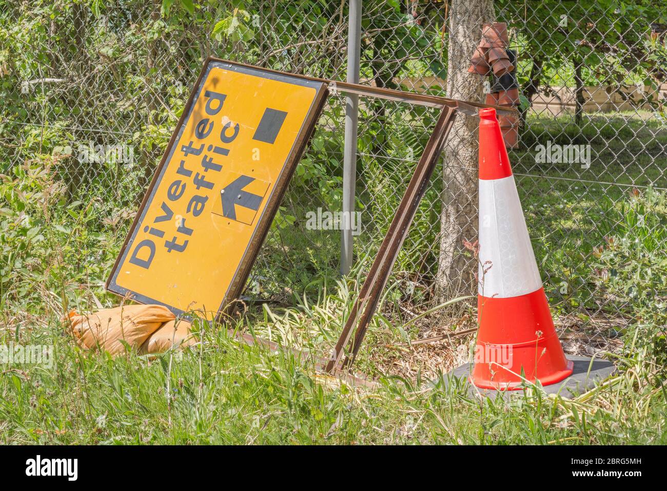 Orange and white road cone & diverted traffic sign on country road ...
