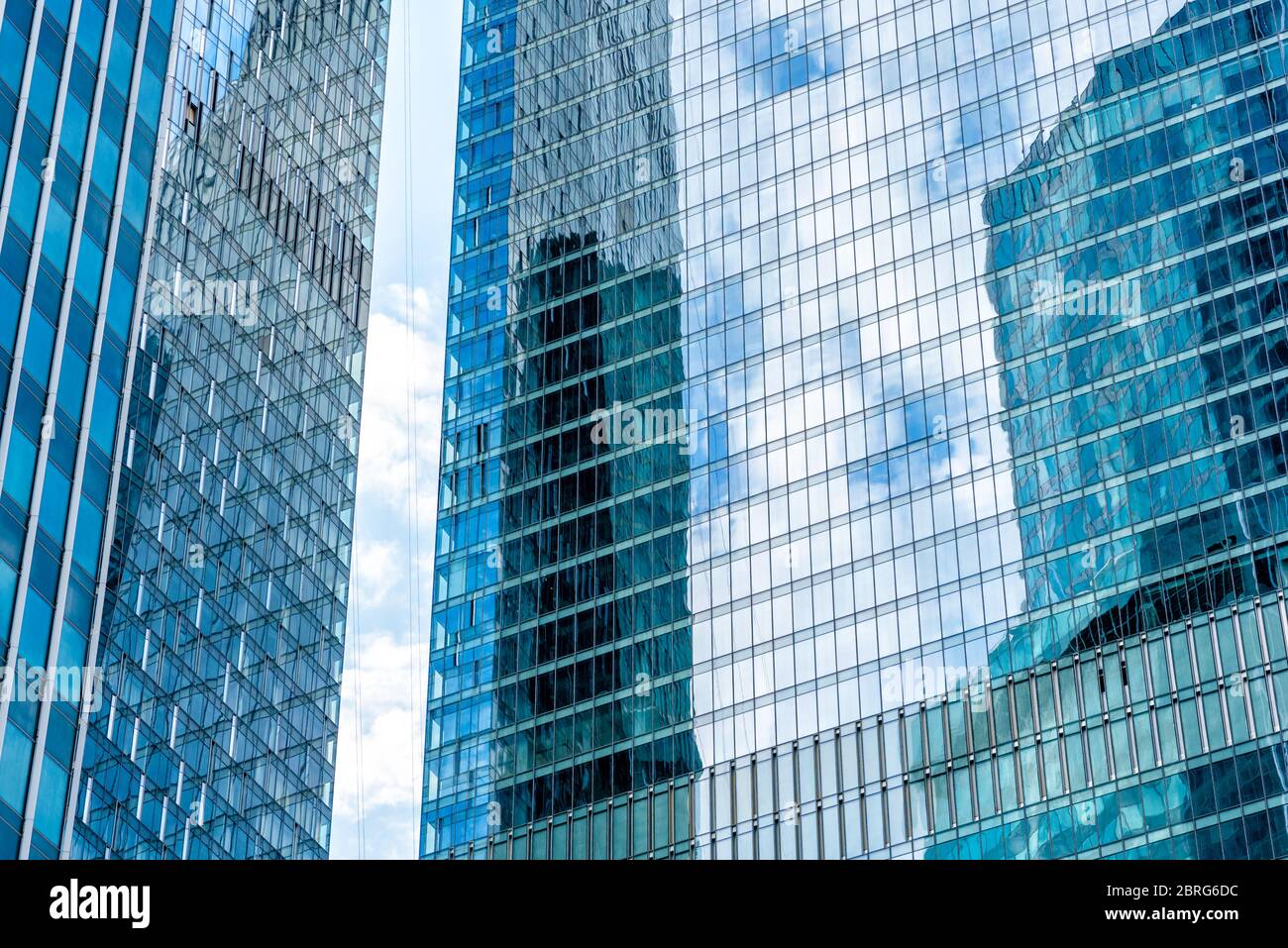 The sky and buildings are reflected in a modern skyscraper. Background ...