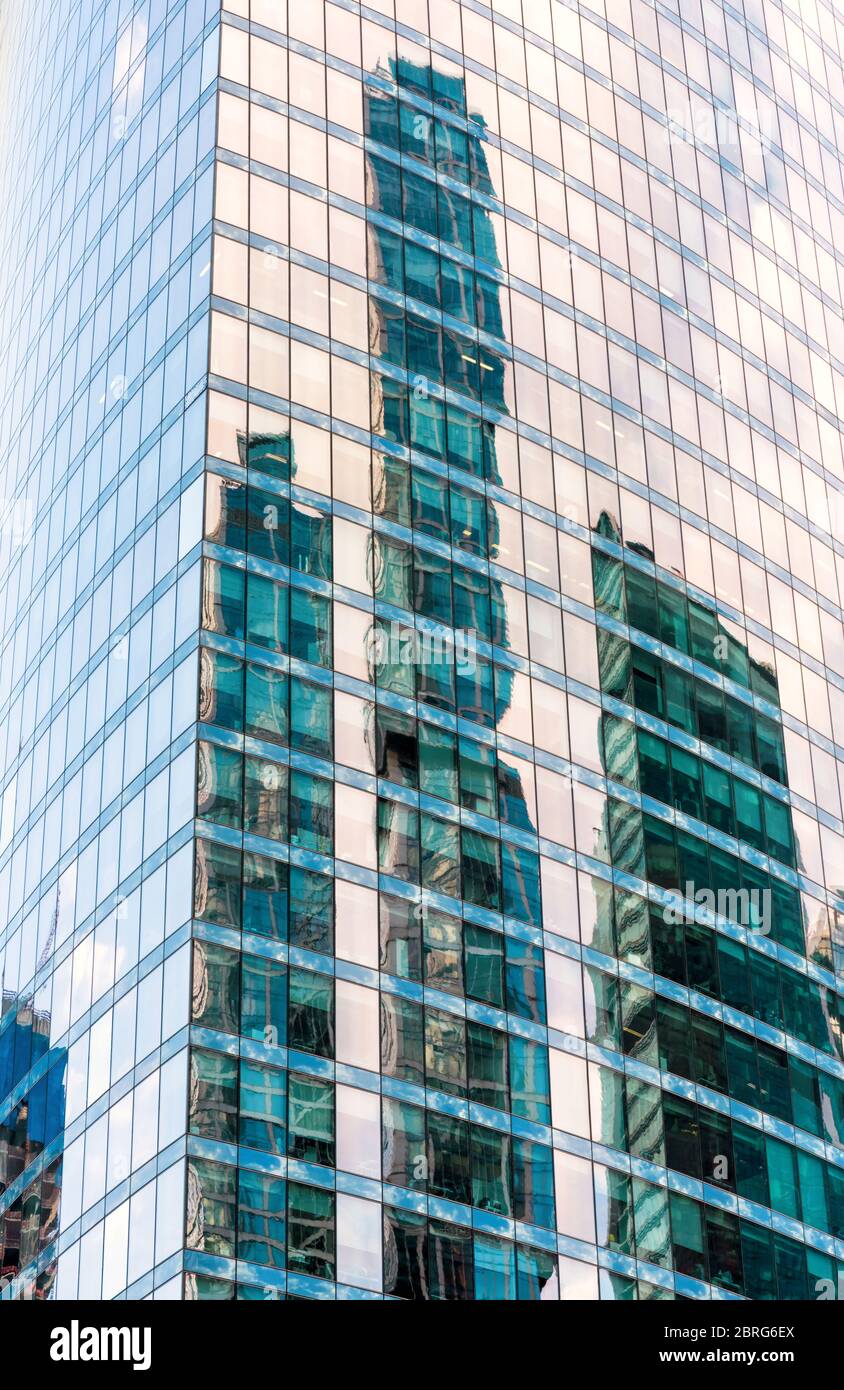 The sky and buildings are reflected in a modern skyscraper. Background ...
