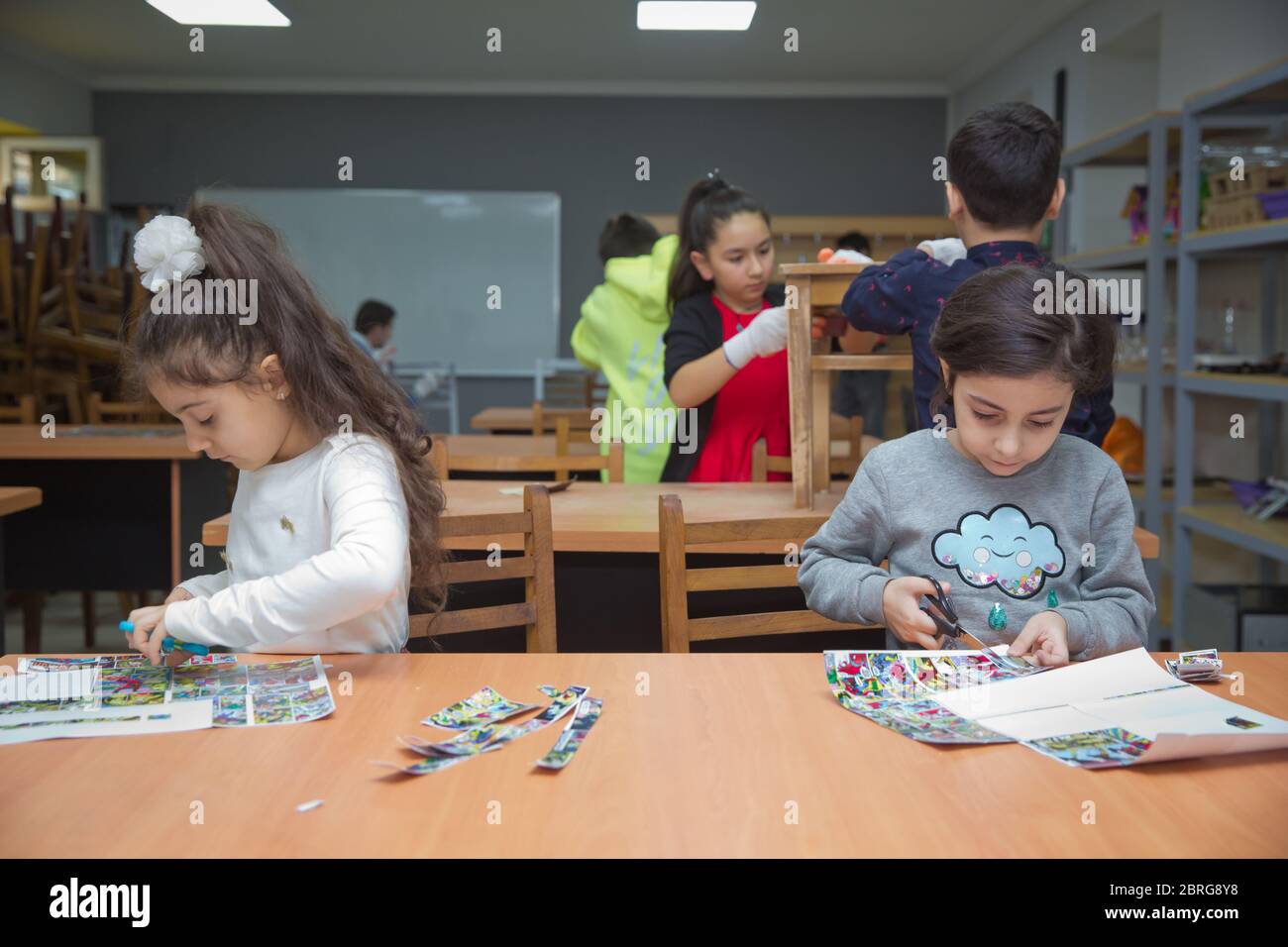 Portrait of a little girl cutting a paper . Little preschooler girl ...