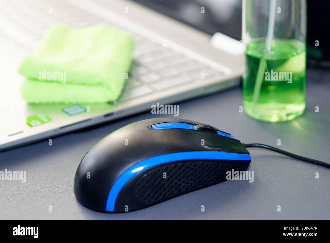 Computer mouse and bottle of sanitizer and a laptop on the desktop in ...