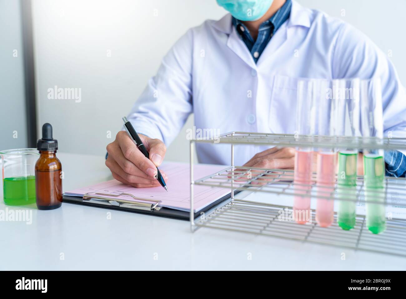 scientists researching in laboratory in white lab coat, gloves ...