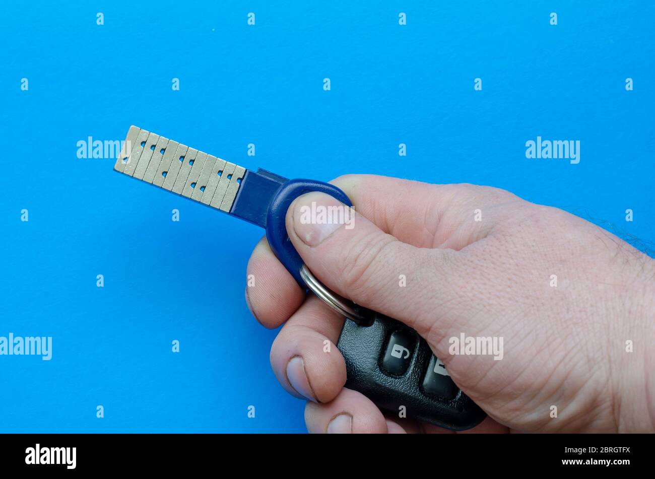 Chipped door key with a remote control in hand. A man demonstrates an ...