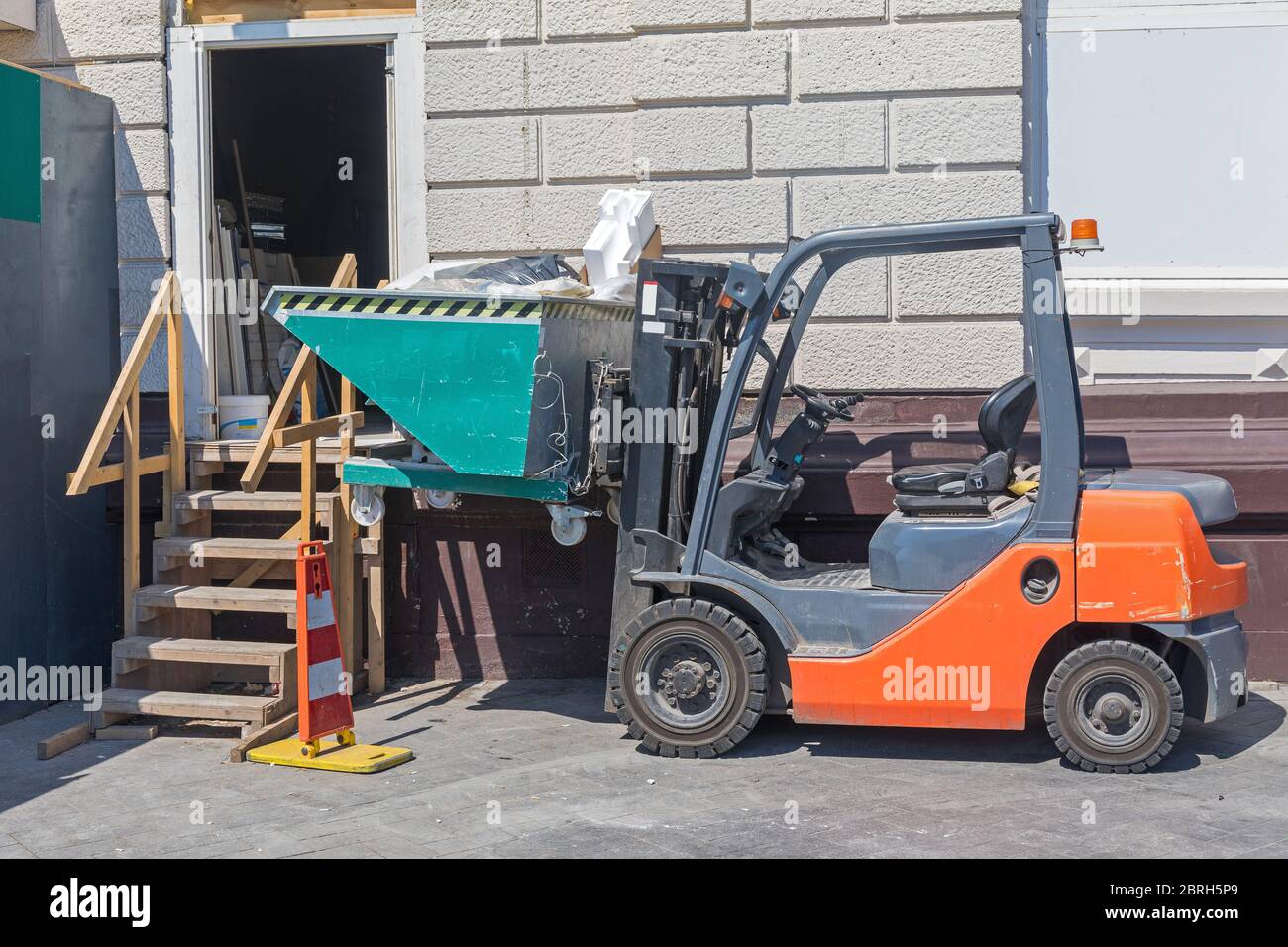 Forklift truck with skip container at construction site hi-res stock ...