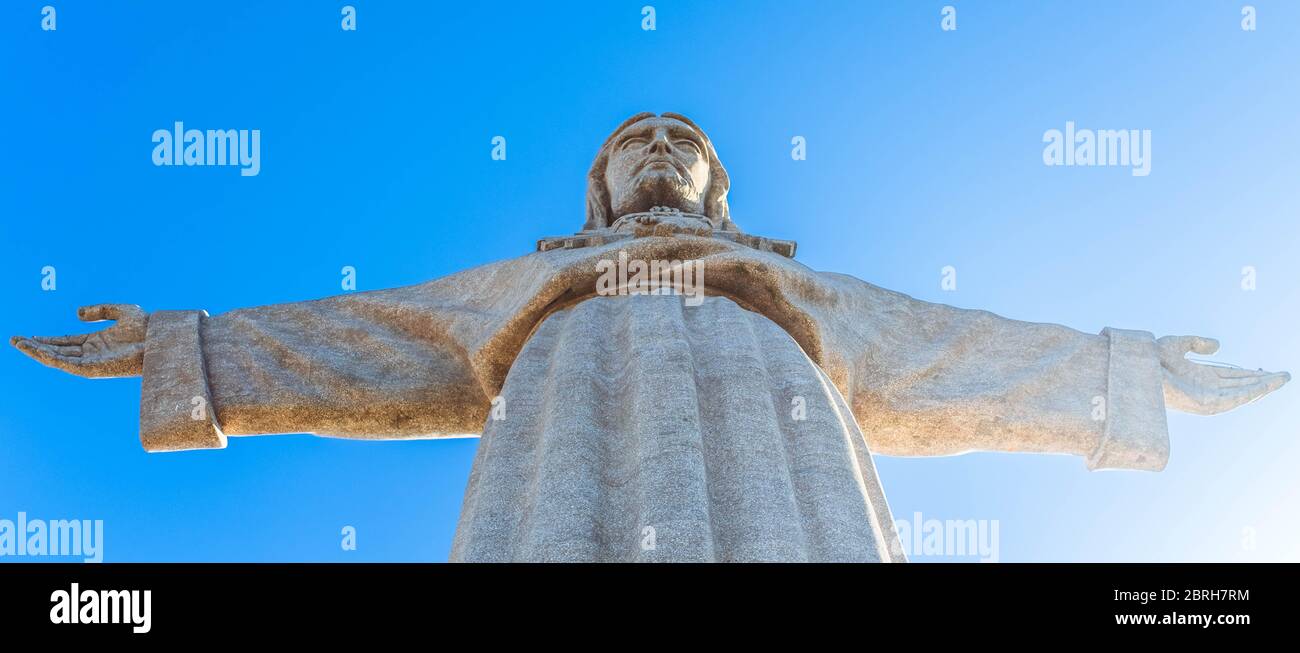 Sculpture of Jesus Christ with opened arms with clear, blue sky on a ...