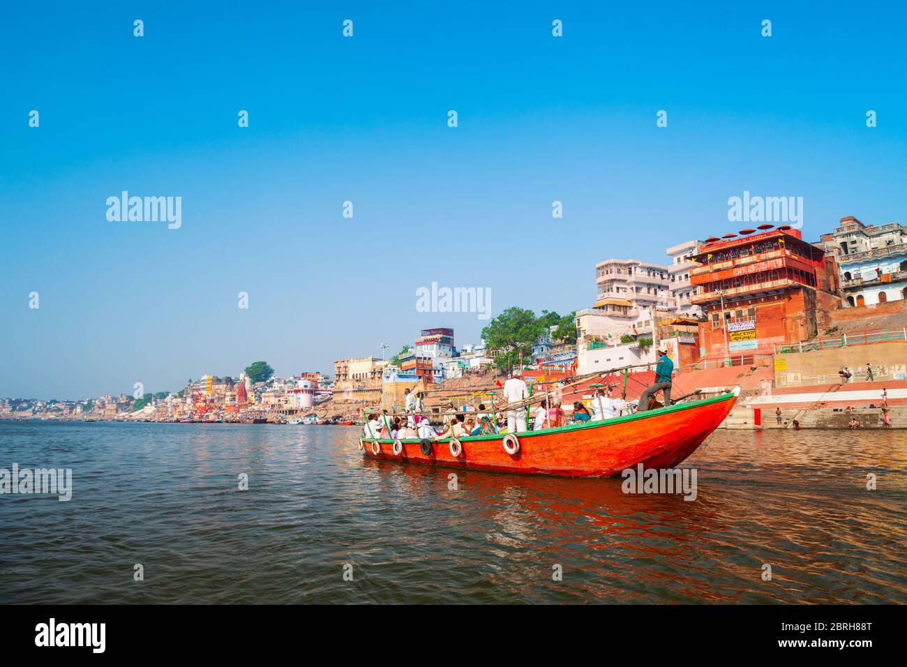 VARANASI, INDIA - APRIL 12, 2012: Colorful boats and Ganges river bank ...