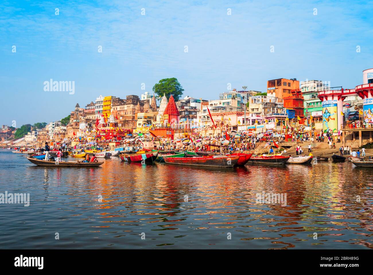 VARANASI, INDIA - APRIL 12, 2012: Colorful boats and Ganges river bank ...