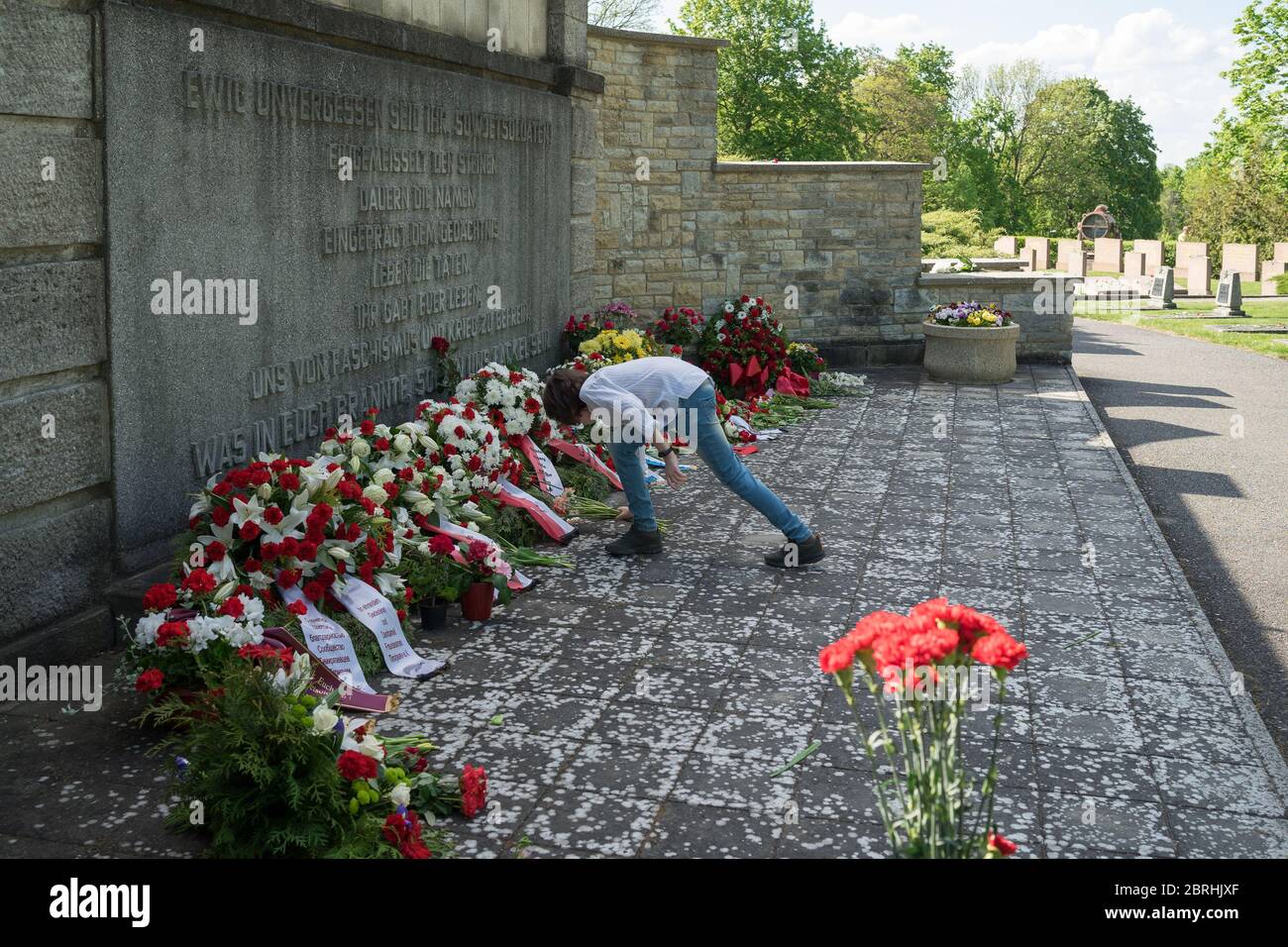 SEELOW, GERMANY - MAY 09, 2020: A boy lays flowers at the foot of the ...