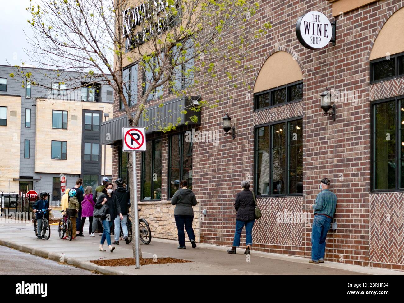 People waiting in line six feet apart at Kowalski's Grocery trying to ...