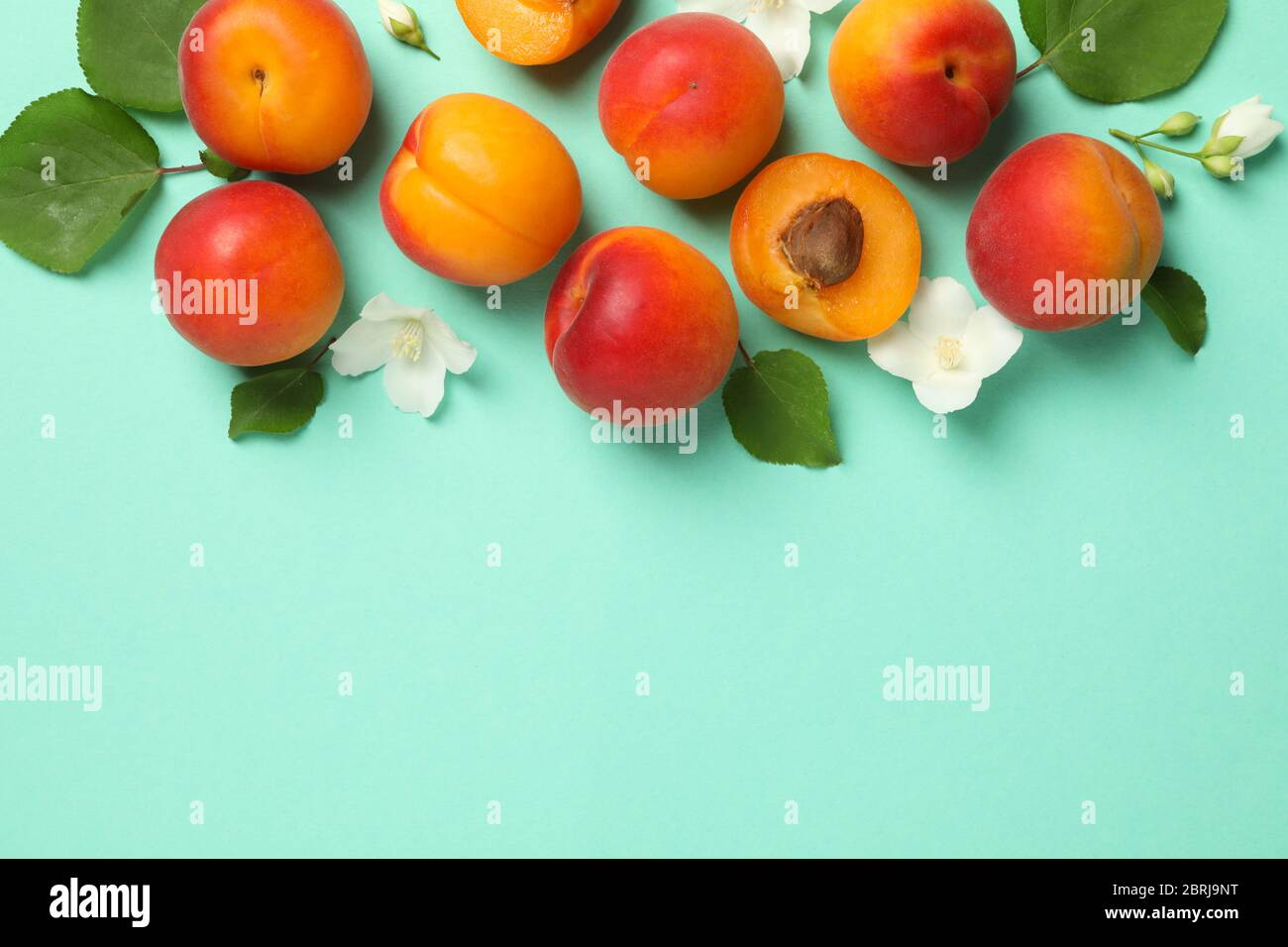Fresh tasty apricots on mint background, top view Stock Photo - Alamy