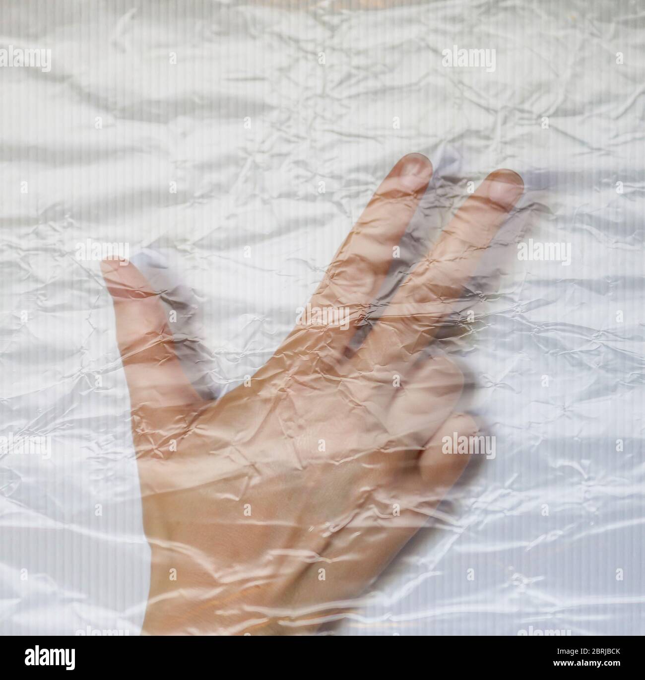 Hand of a young female wrapped in plastic film showing different ...