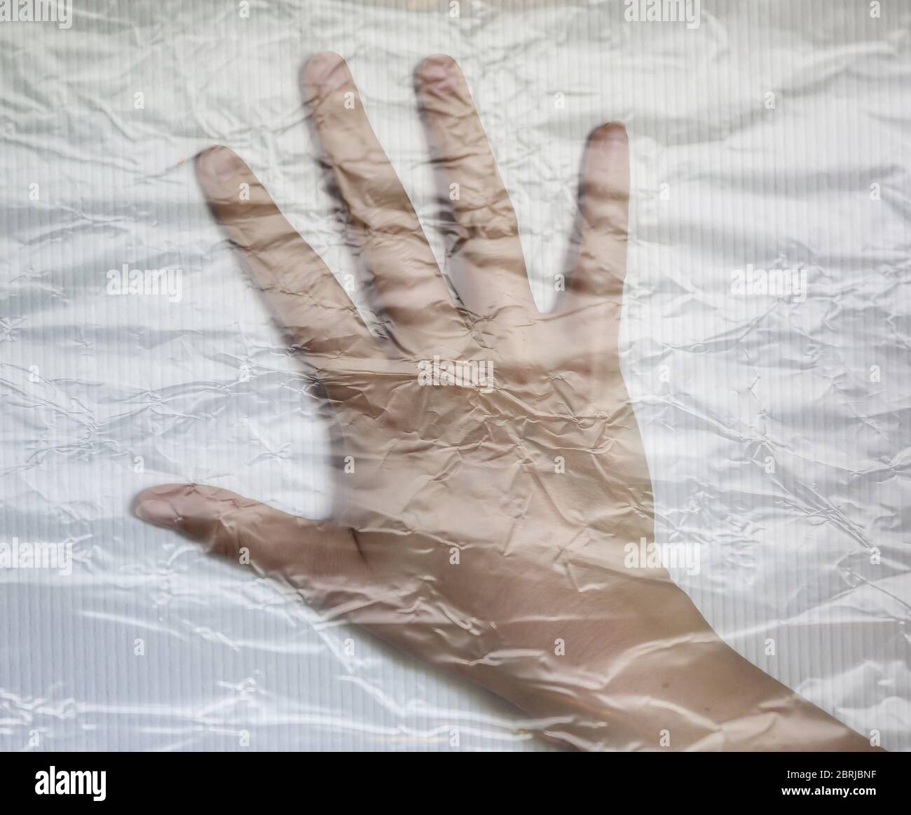Hand of a young female wrapped in plastic film showing different ...