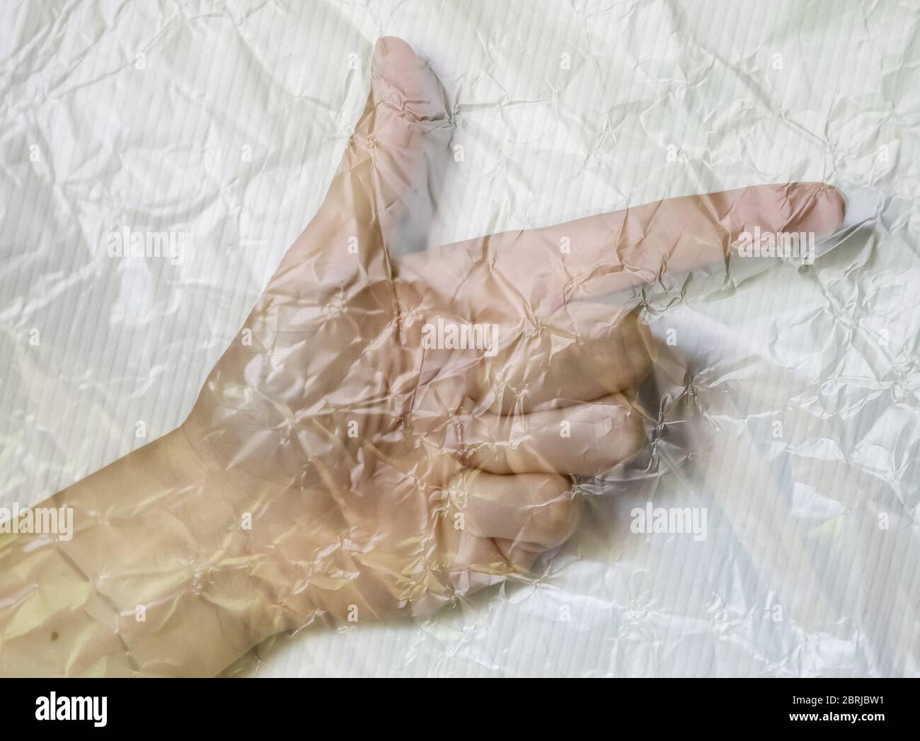 Hand of a young female wrapped in plastic film showing different ...