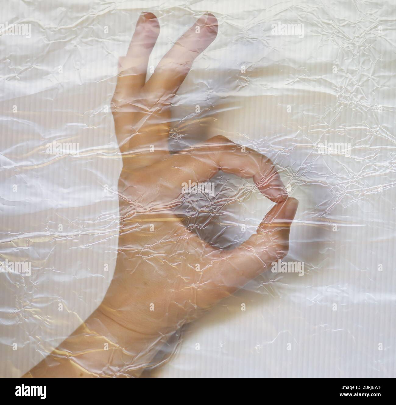 Hand of a young female wrapped in plastic film showing different ...