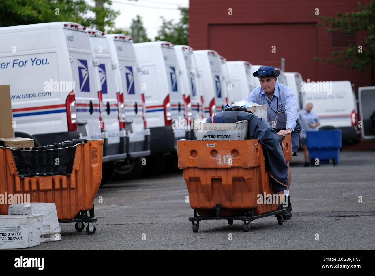 Portland, USA. 21st May, 2020. A postal worker loads mail into vehicles ...