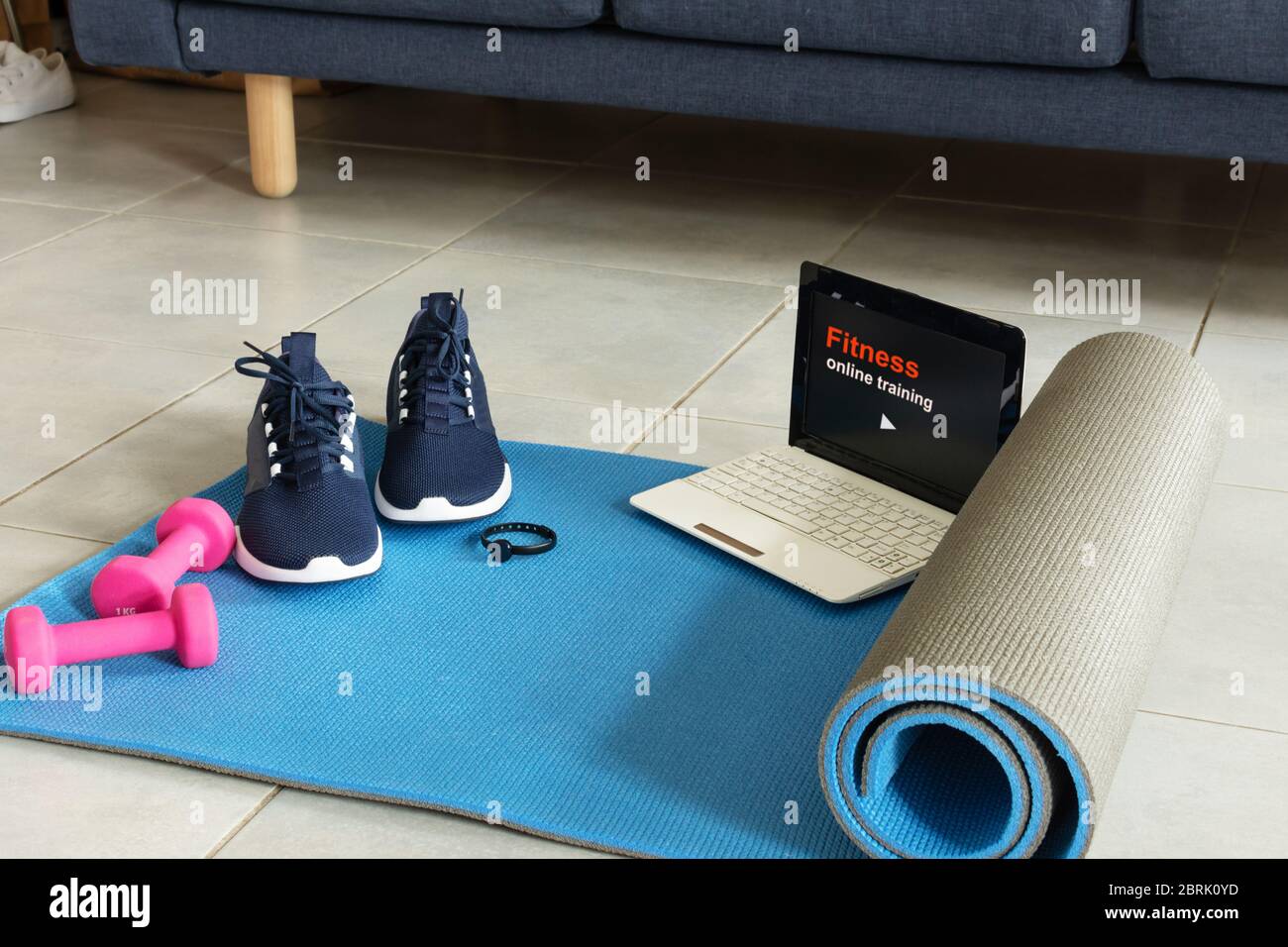 Fitness sports equipment and laptop over home living room background ...