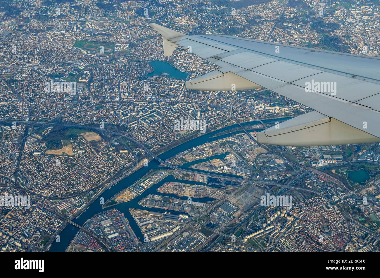 View over the clouds from the porthole of an airplane with plane wing ...