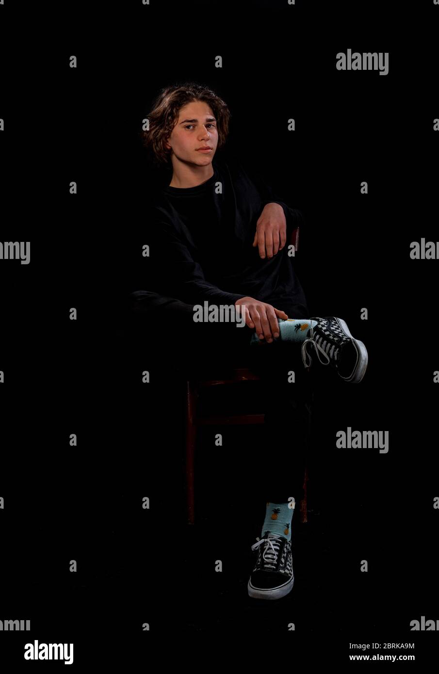 Cool young man dressed in black sweater, black jeans and sneakers ...