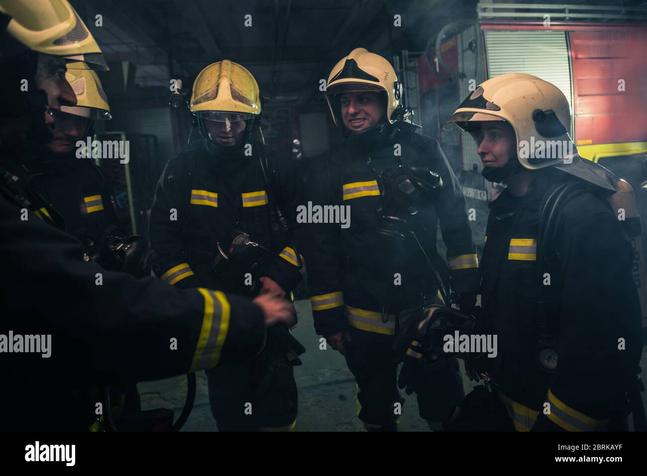 Team of firefighters standing inside ( indoors ) a buliding next to a ...