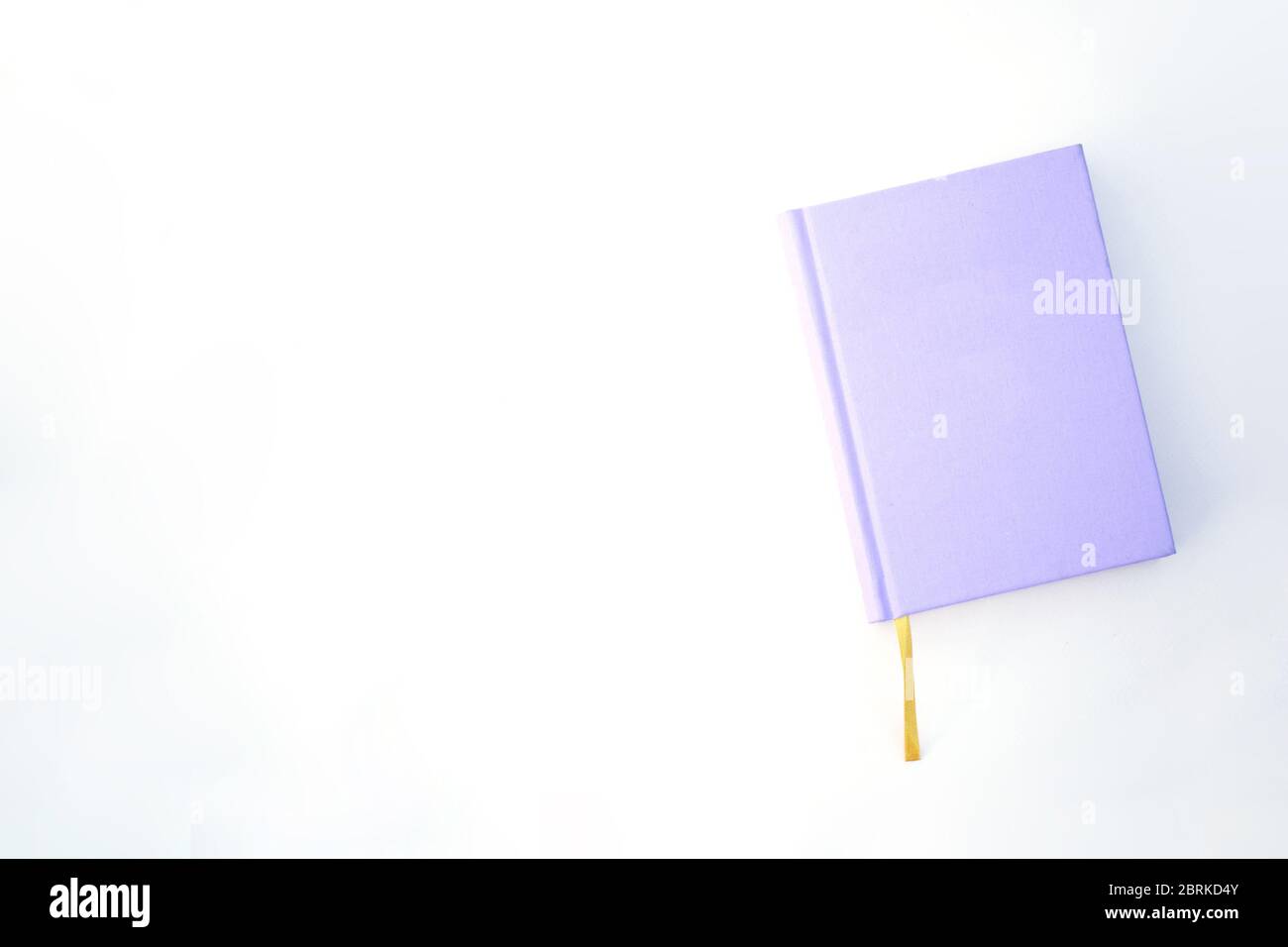 Purple notebook or book on the bright background with the yellow ribbon ...