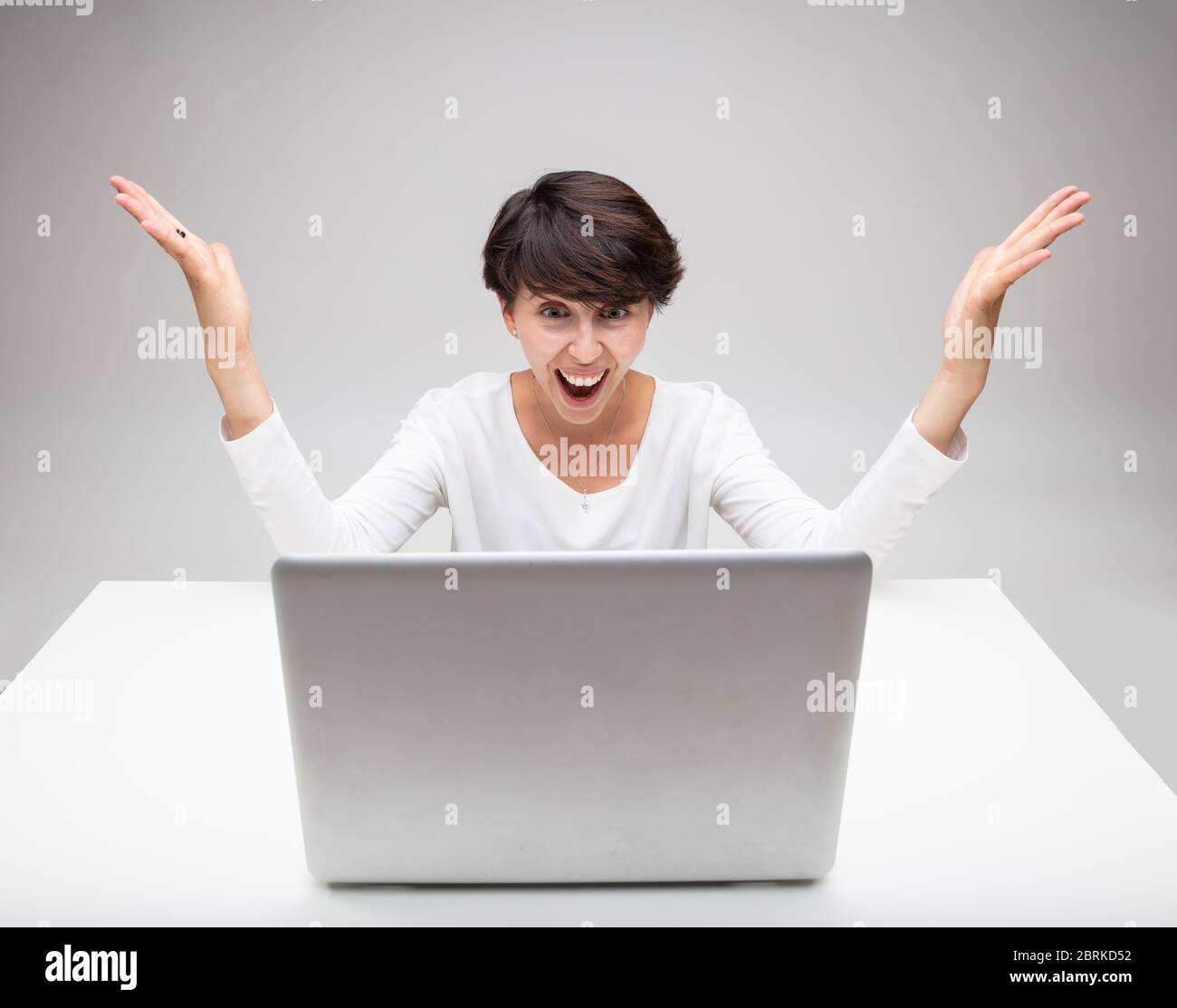 Incredulous business woman gawping at a laptop computer gesturing with ...