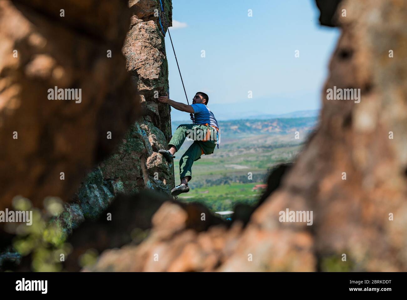 Rock climber climbs the cliff using ropes and equipment, the employment ...