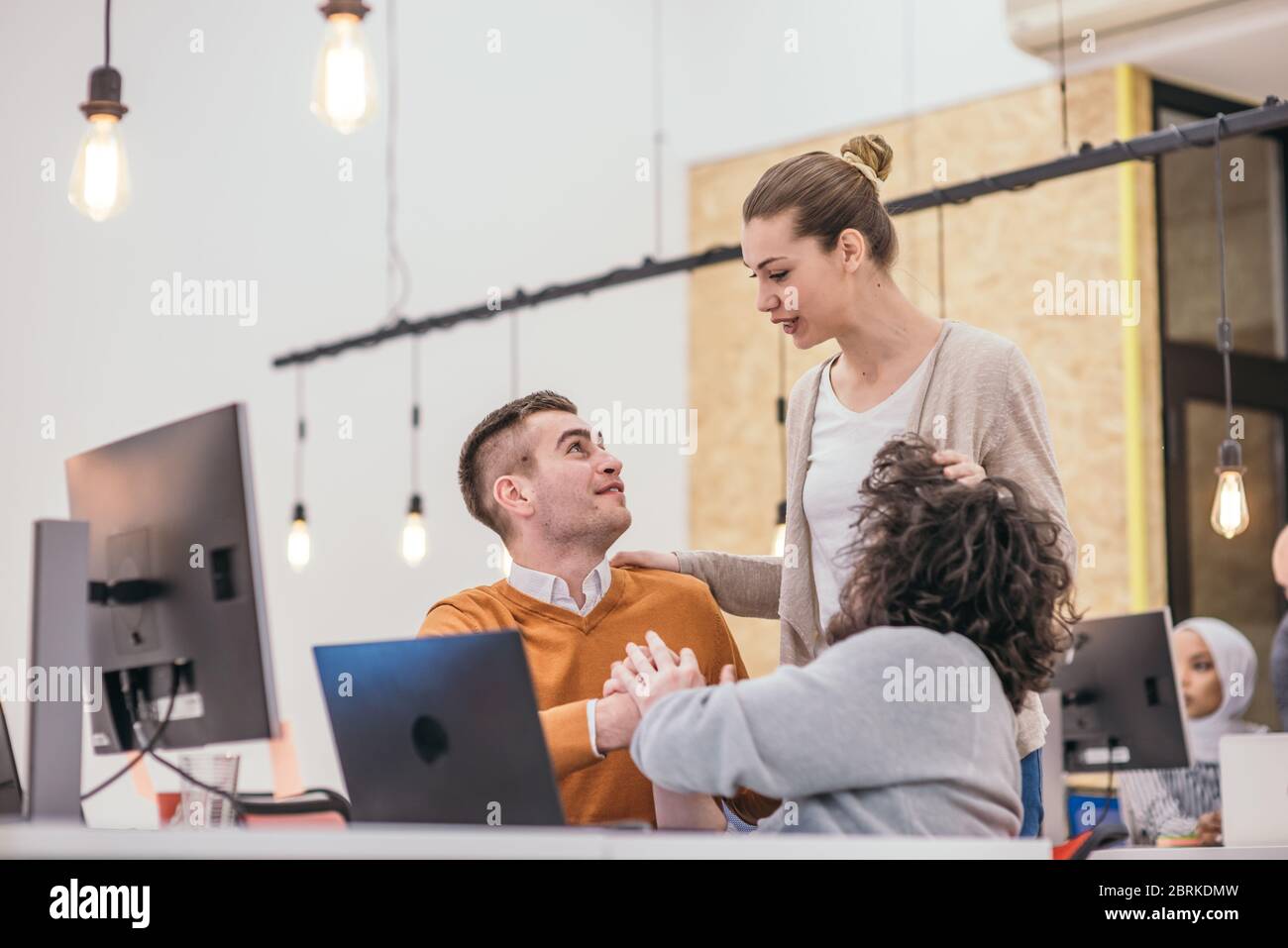 Happy surprise for the teammates. Coworkers cheering while looking at a ...