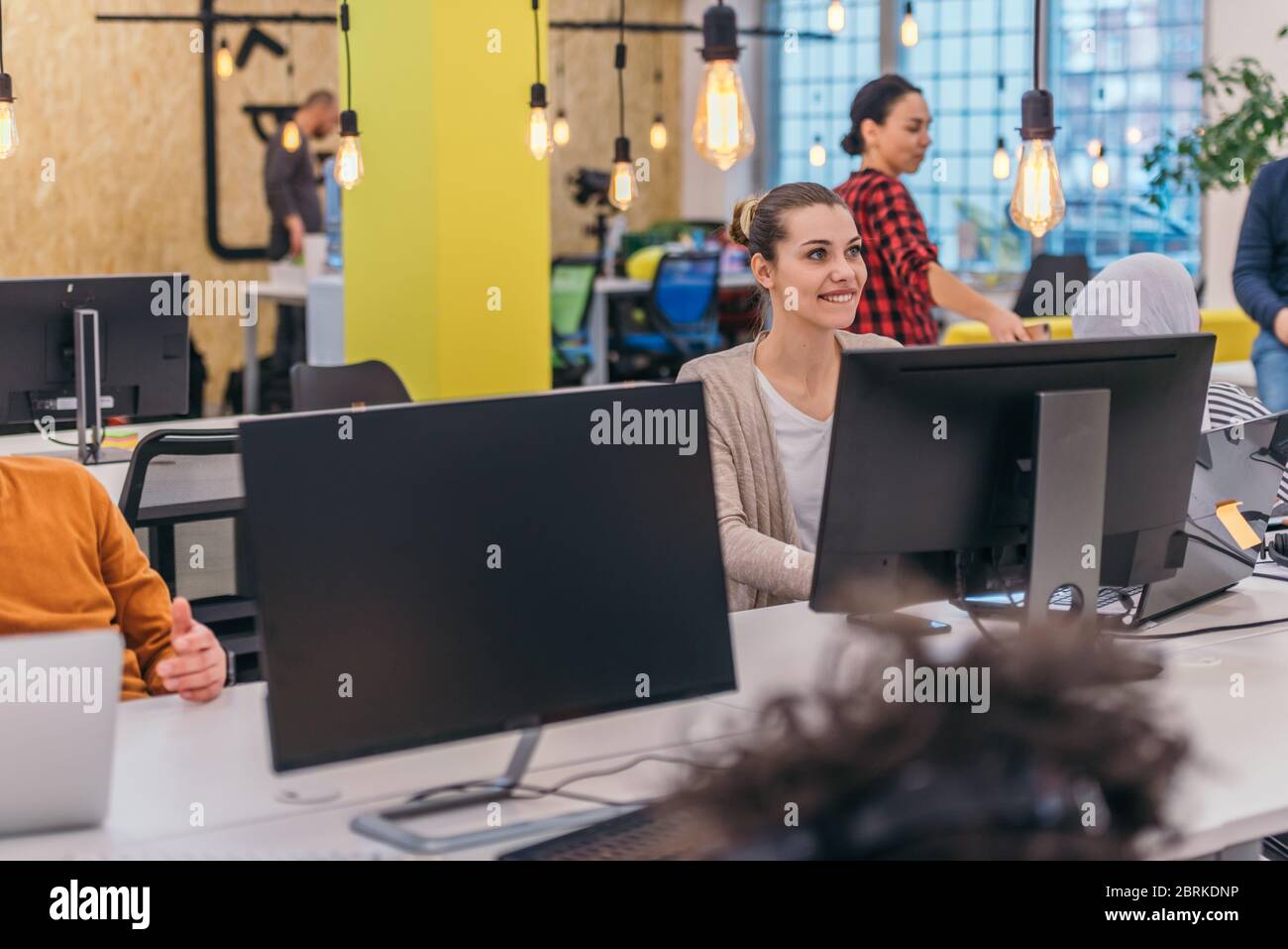 An attractive businesswoman working on a computer and talking with her ...