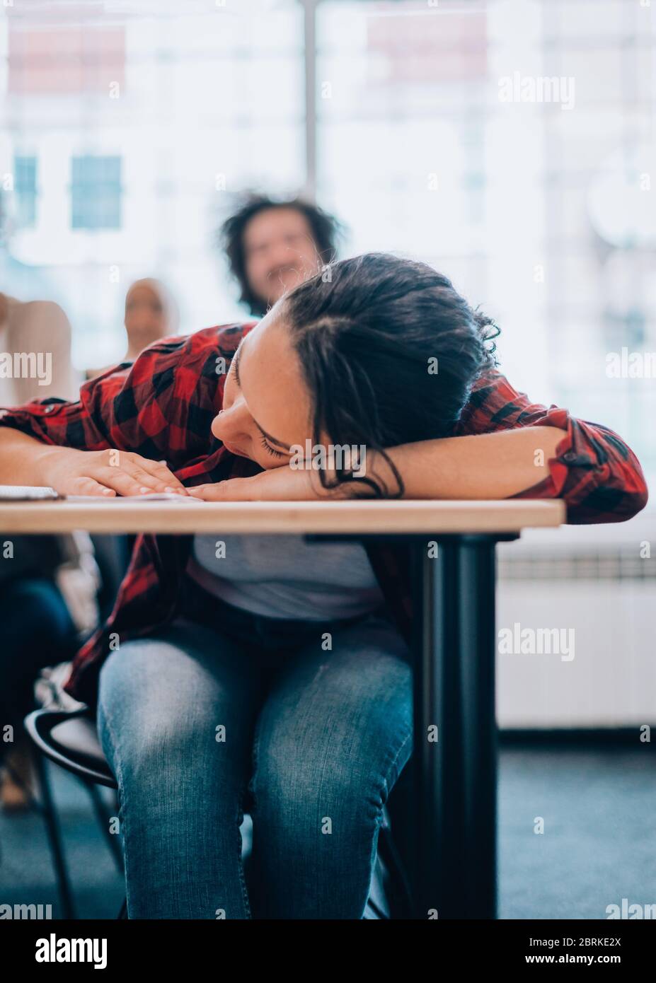 Tired girl napping on the table during a lecture in the classroom Stock ...
