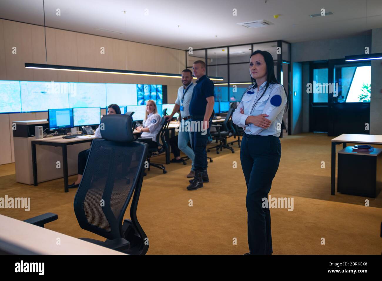 Security guards standing in front of a large CCTV monitor at the main ...
